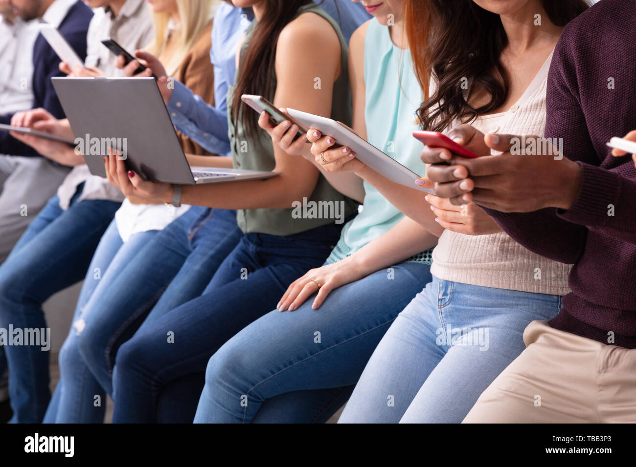 Multiracial Millennial People In Row Busy In Using Modern Electronic ...