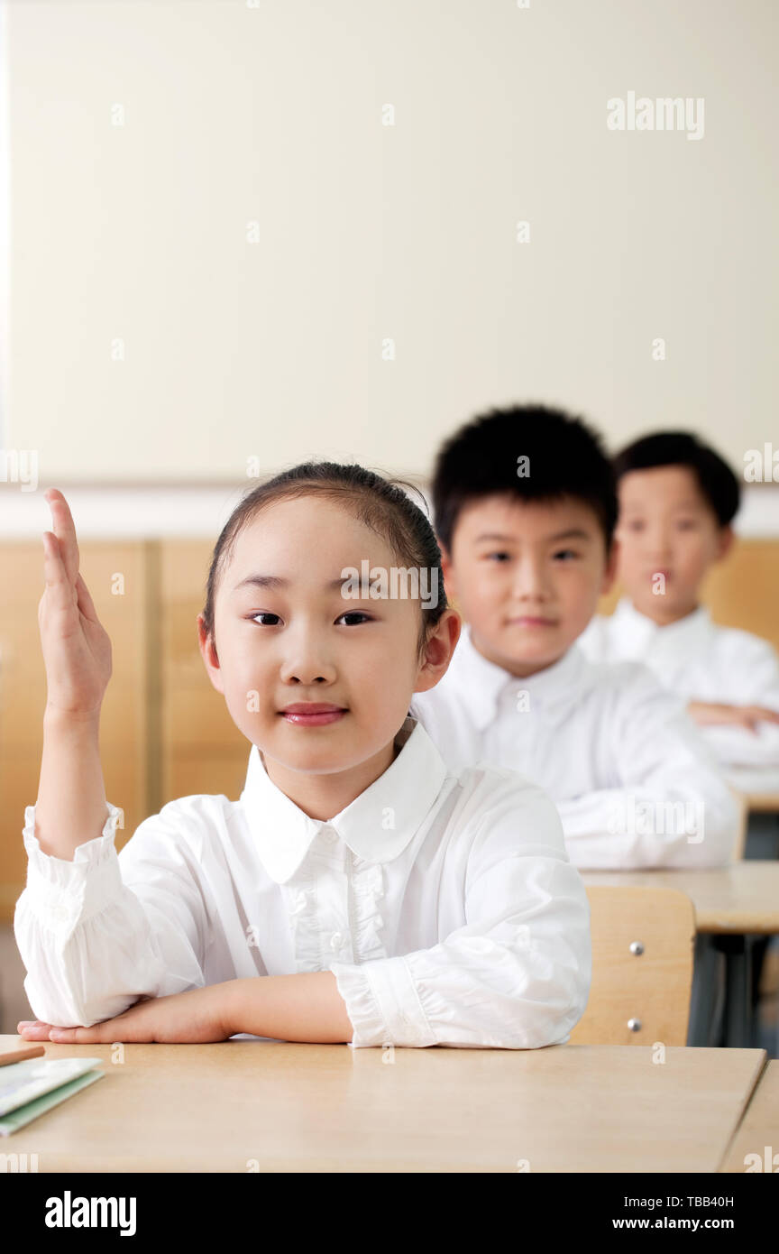 Three primary school students are in class in the classroom Stock Photo ...