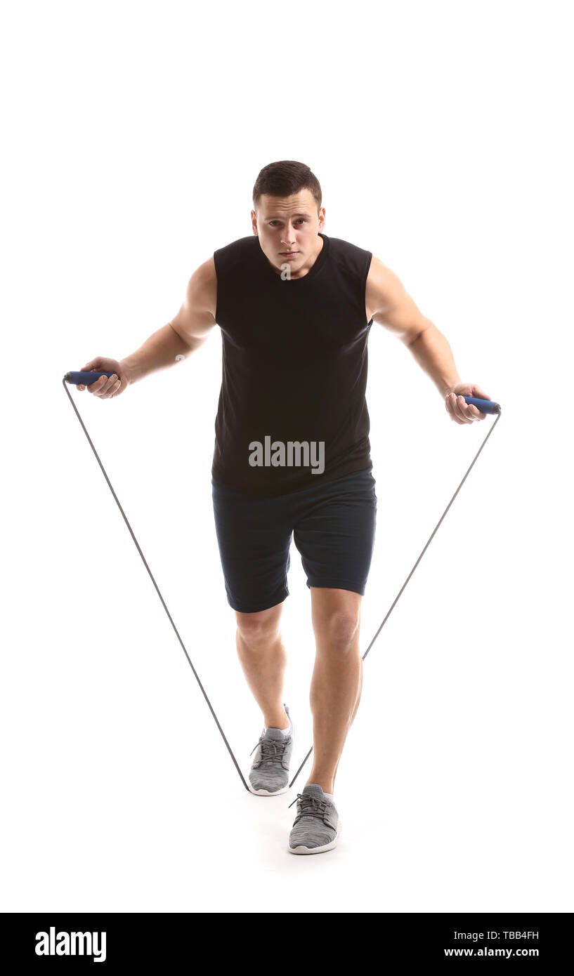 Sporty young man with jumping rope against white background Stock Photo ...