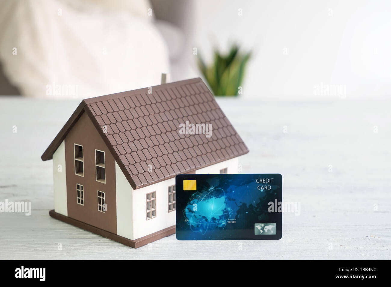 Figure of house and credit card on table. Concept of buying property ...