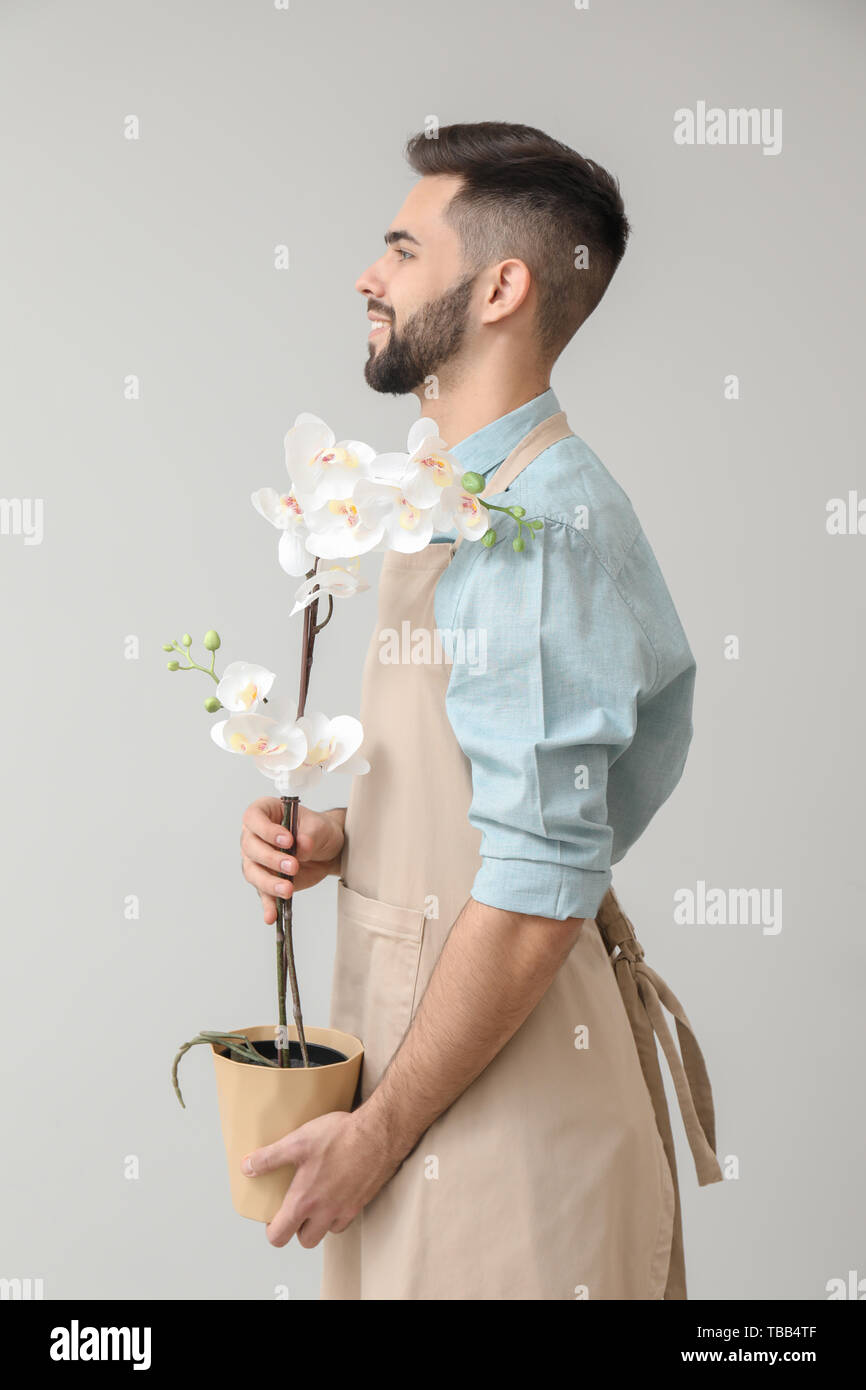 Handsome male florist on light background Stock Photo - Alamy