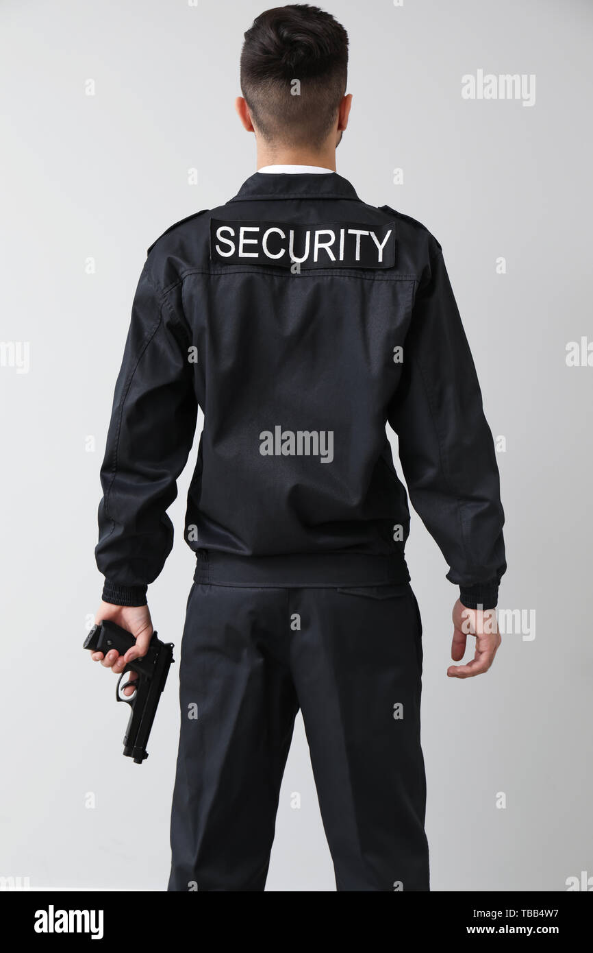Male security guard on light background Stock Photo - Alamy