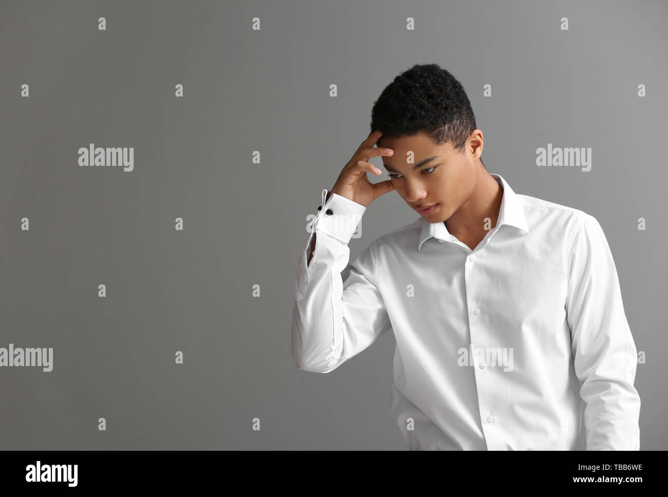 Sad African-American boy after failing school test on grey background ...