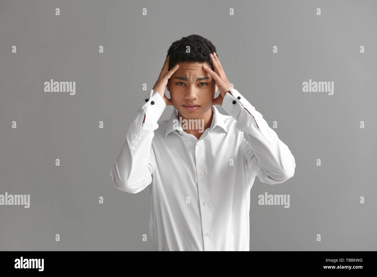 Sad African-American boy after failing school test on grey background ...