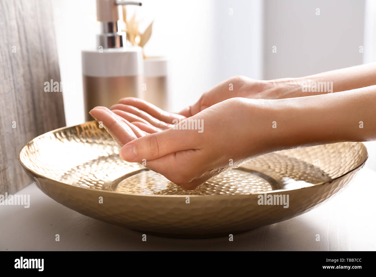 Woman washing hands in golden bowl Stock Photo - Alamy