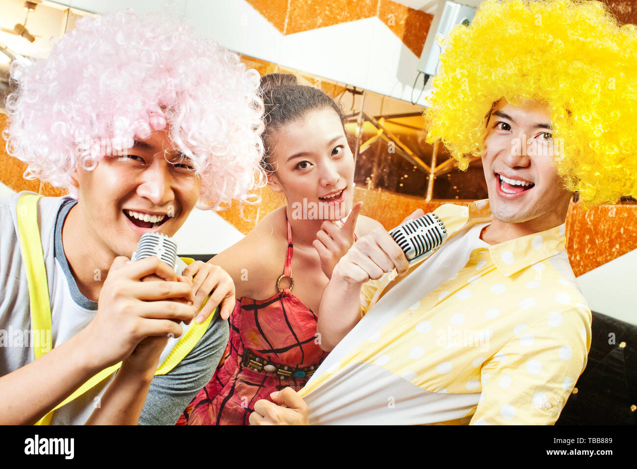Three friends sing at KTV party Stock Photo - Alamy