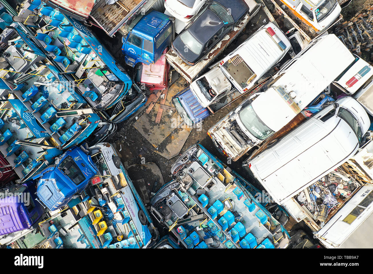 Piled together, scrap-out old motor vehicles waiting to be dismantled ...