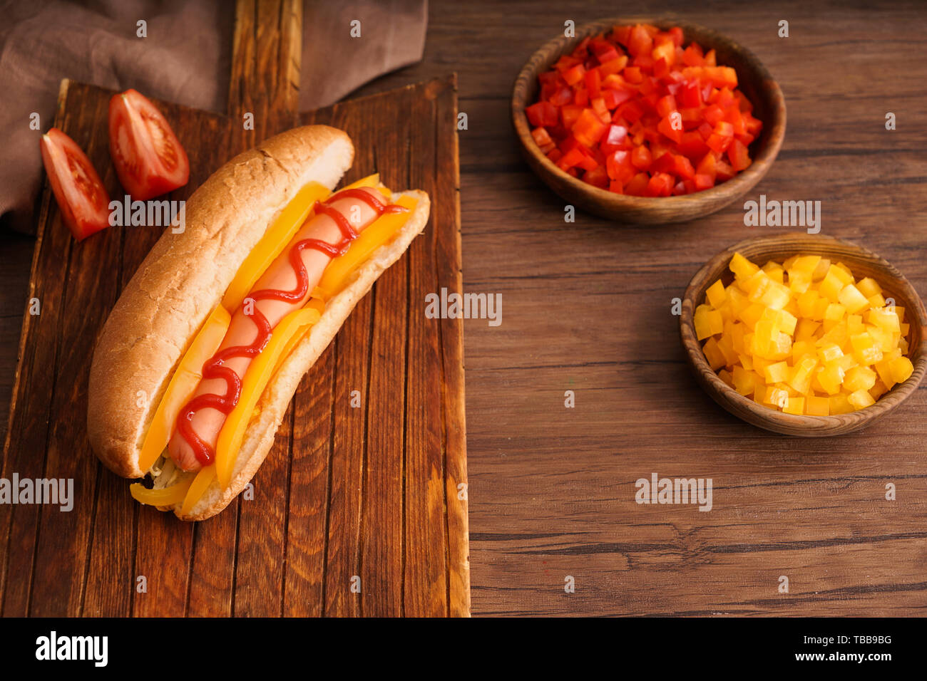 Board with tasty hot dog on wooden table Stock Photo - Alamy