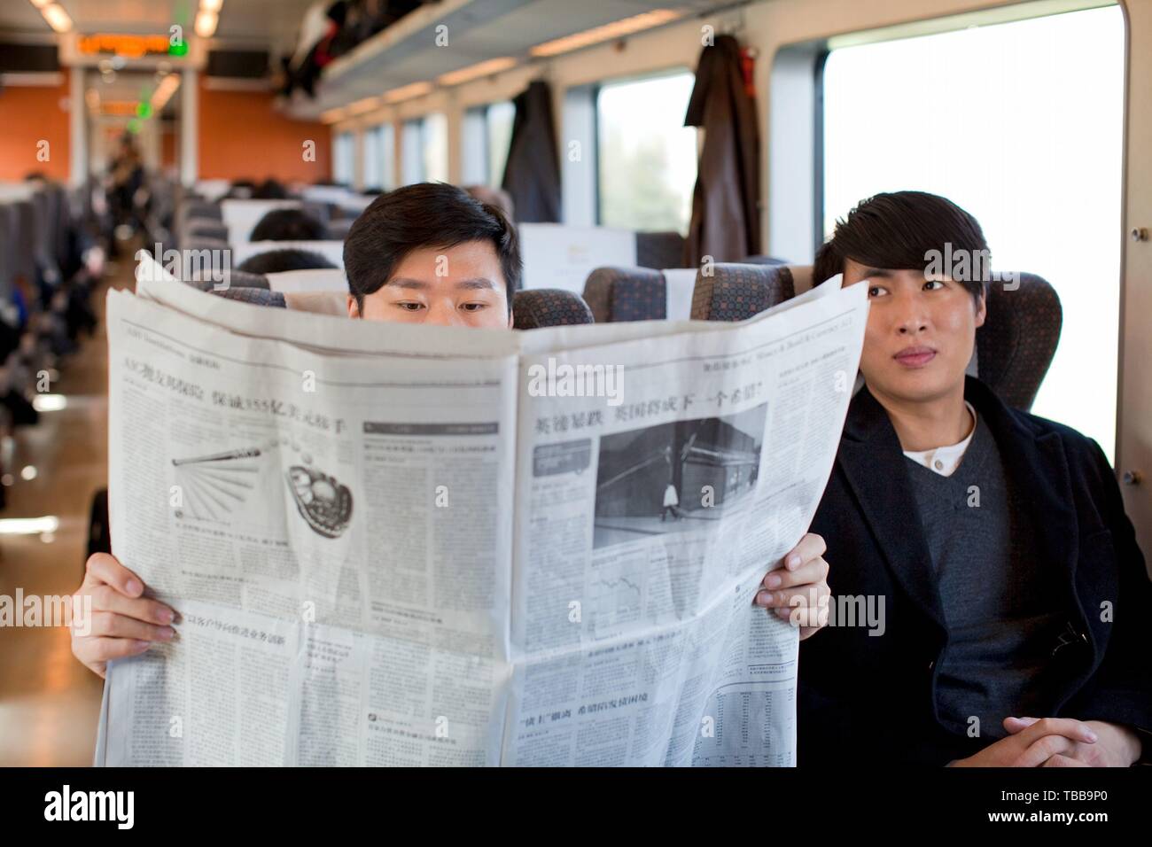 Asian man newspaper train hi-res stock photography and images - Alamy