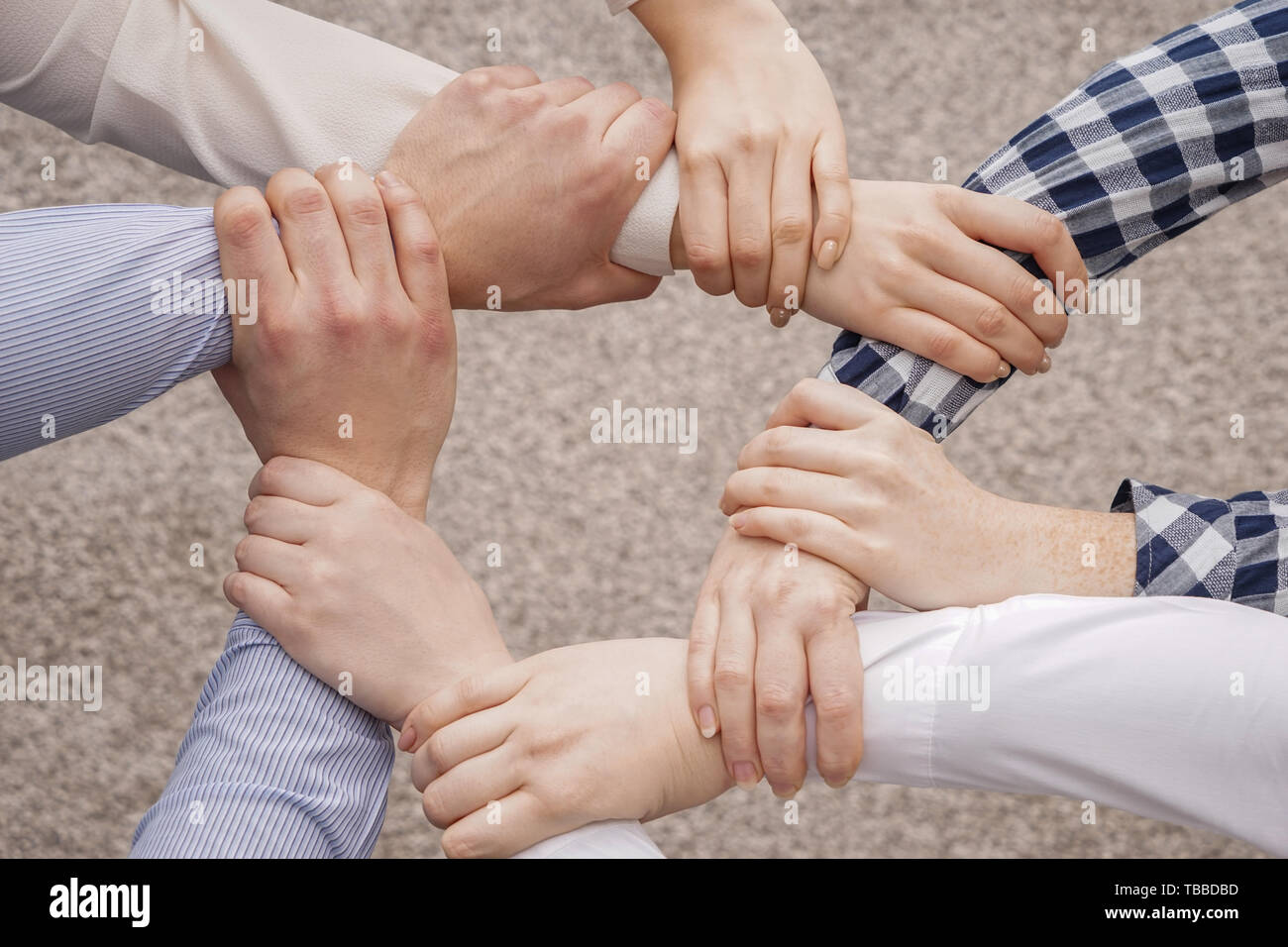 Group of people holding hands on light background. Unity concept Stock ...