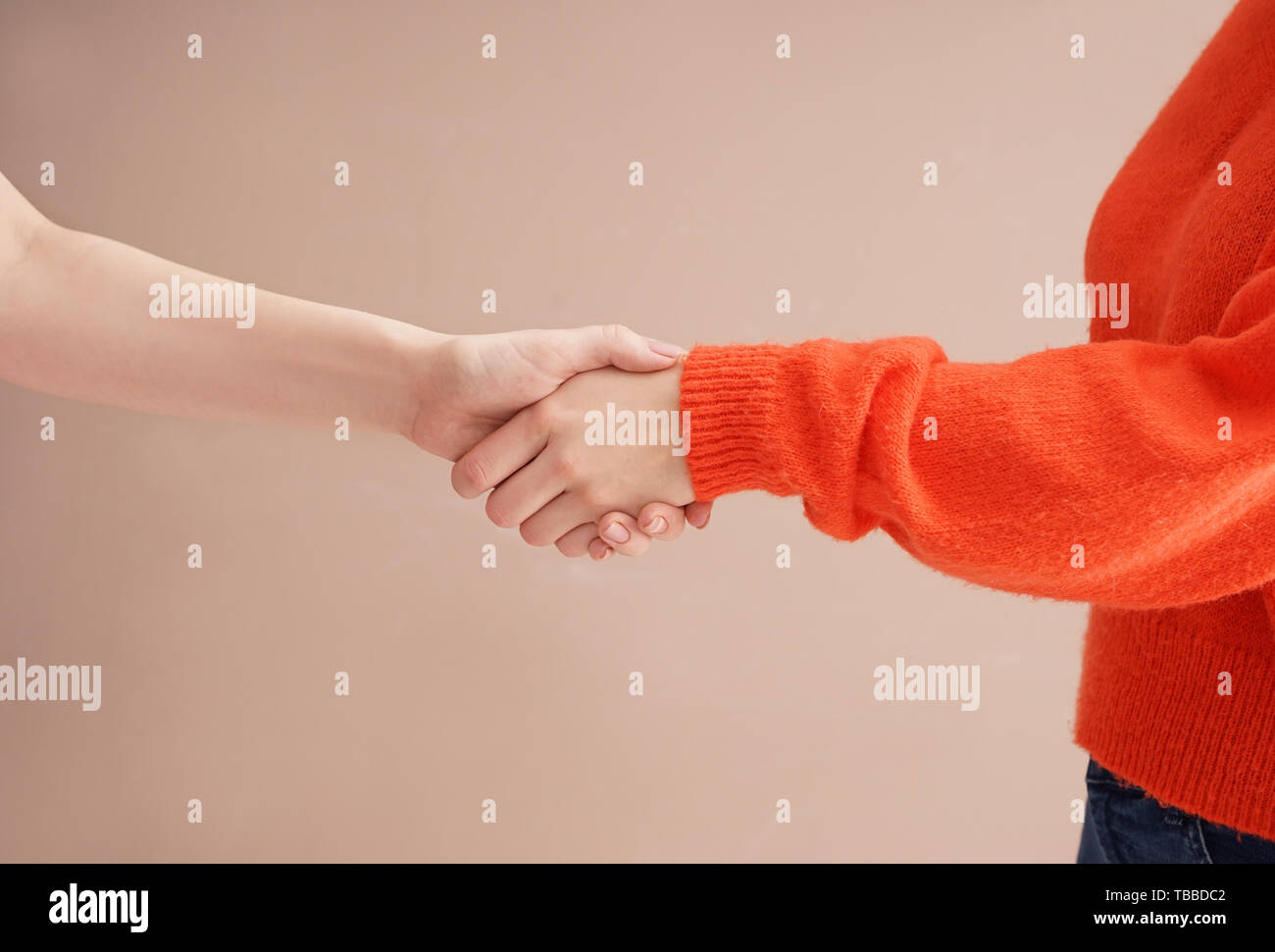 Friends shaking hands on color background Stock Photo - Alamy