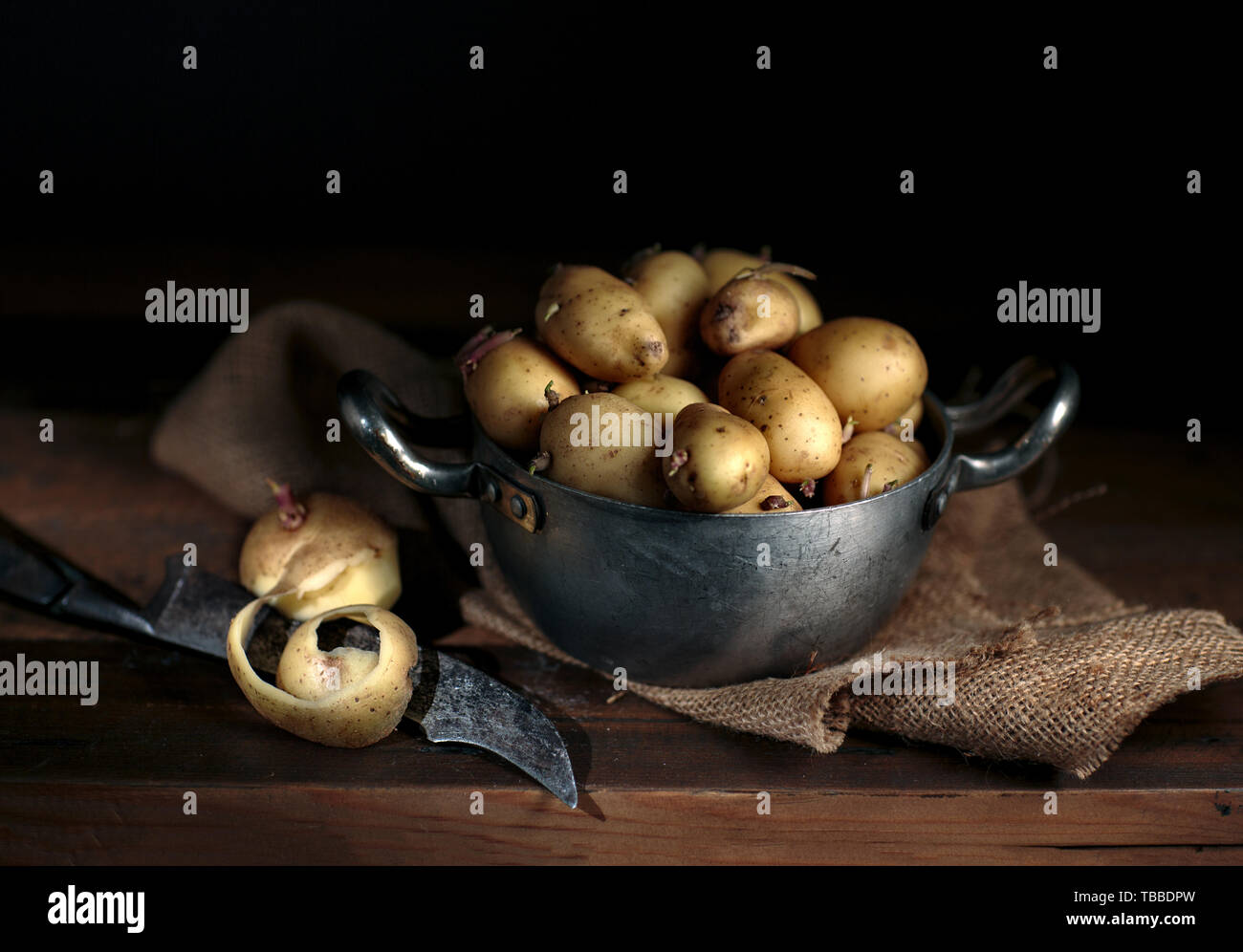 Rustic Still Life with Potatoes in old cooking pot and knife Stock ...