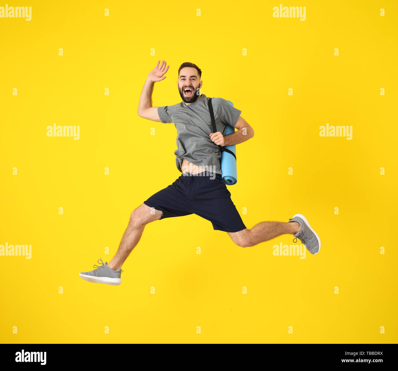 Young sporty man jumping against color background Stock Photo - Alamy