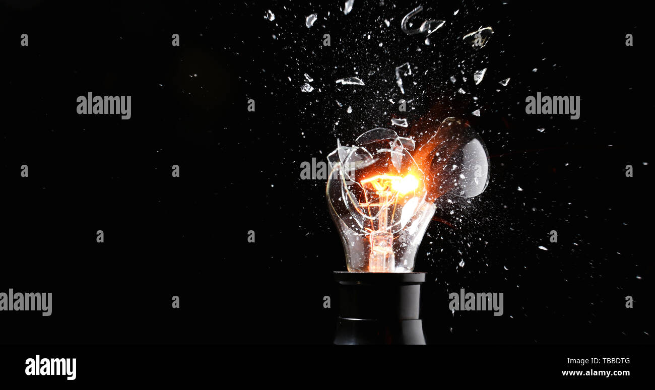 Breaking of light bulb on dark background Stock Photo - Alamy
