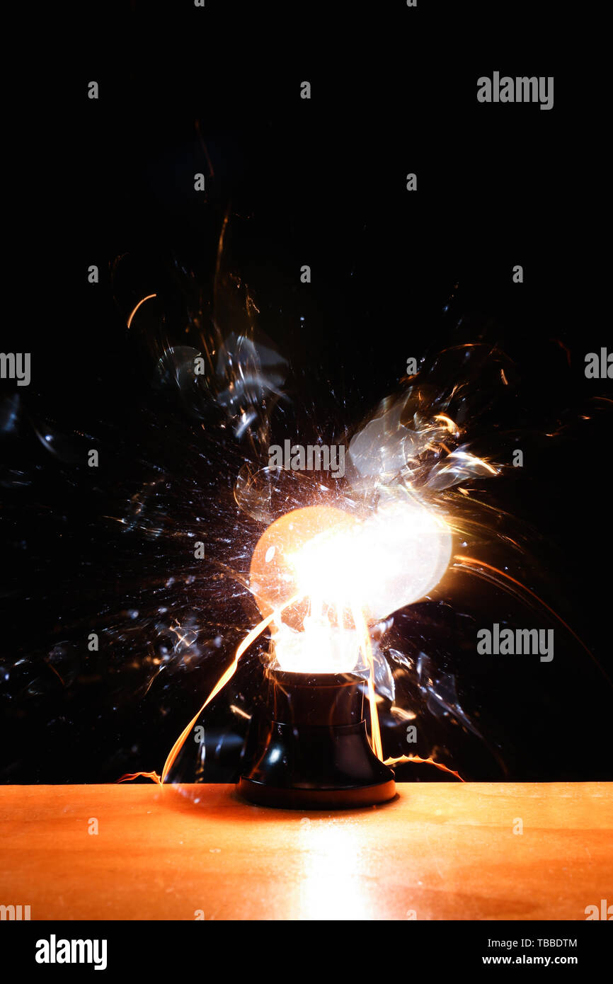 Breaking of light bulb on dark background Stock Photo - Alamy