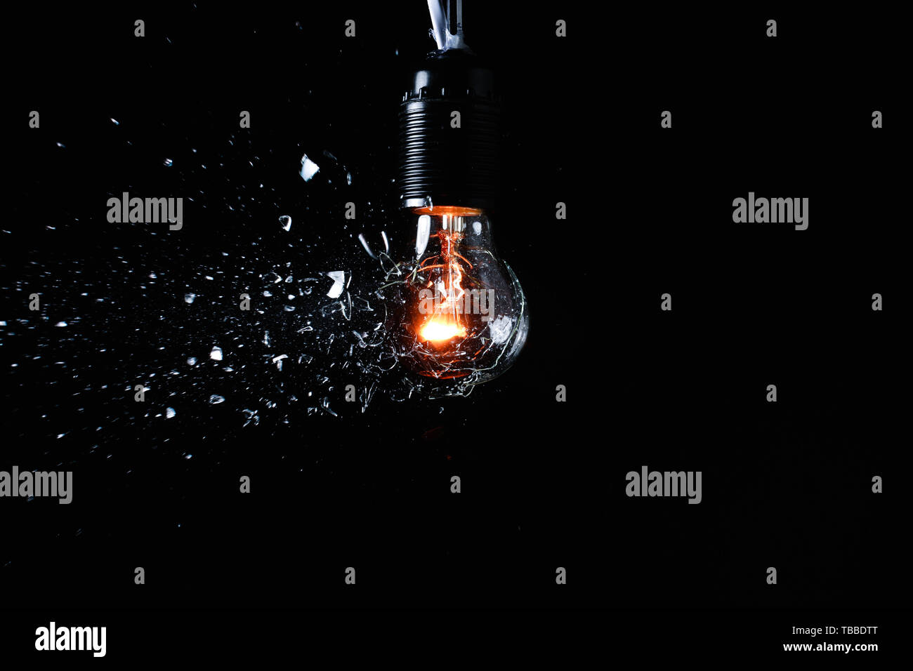Breaking of light bulb on dark background Stock Photo - Alamy
