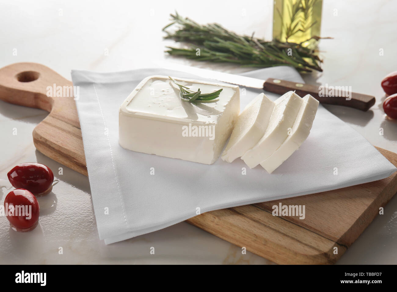 Board with cut feta cheese on table Stock Photo - Alamy