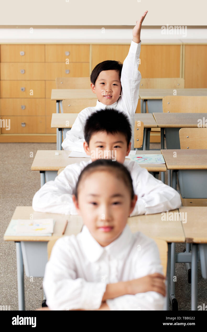 Three primary school students are in class in the classroom Stock Photo ...