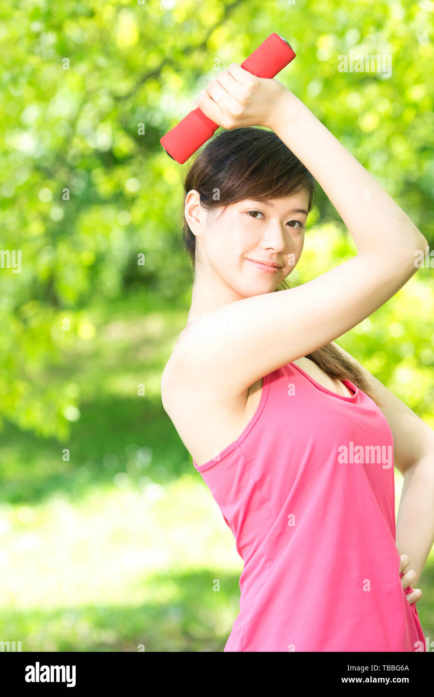 A young woman performs a fitness exercise on a summer day Stock Photo ...
