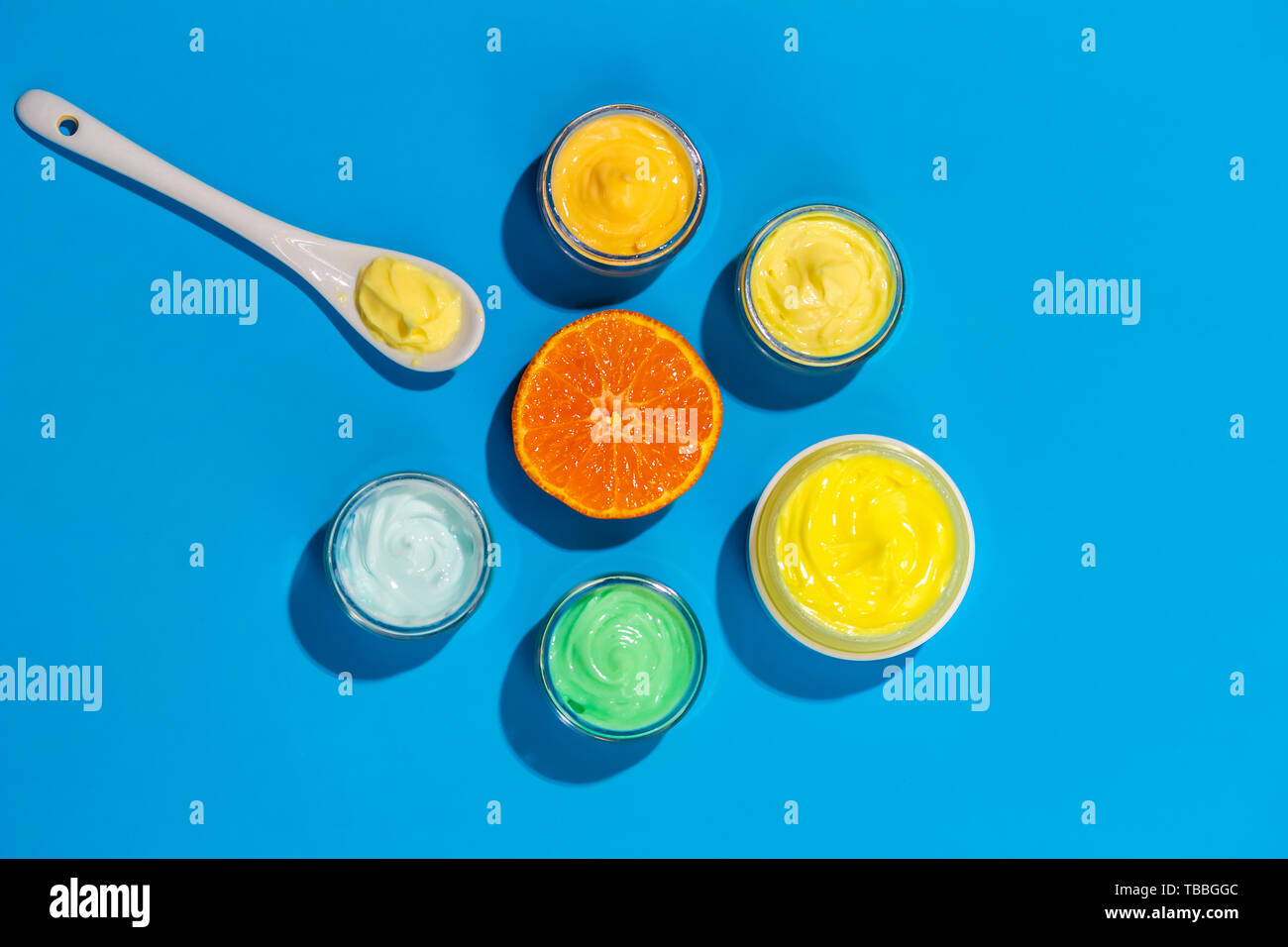 Face cream and orange on a bright blue background. Cosmetics from ...