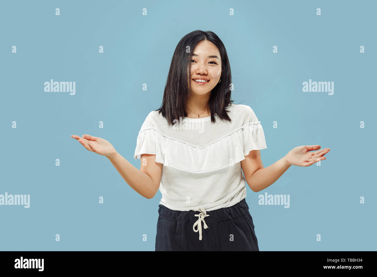 Korean young woman's half-length portrait on blue studio background ...