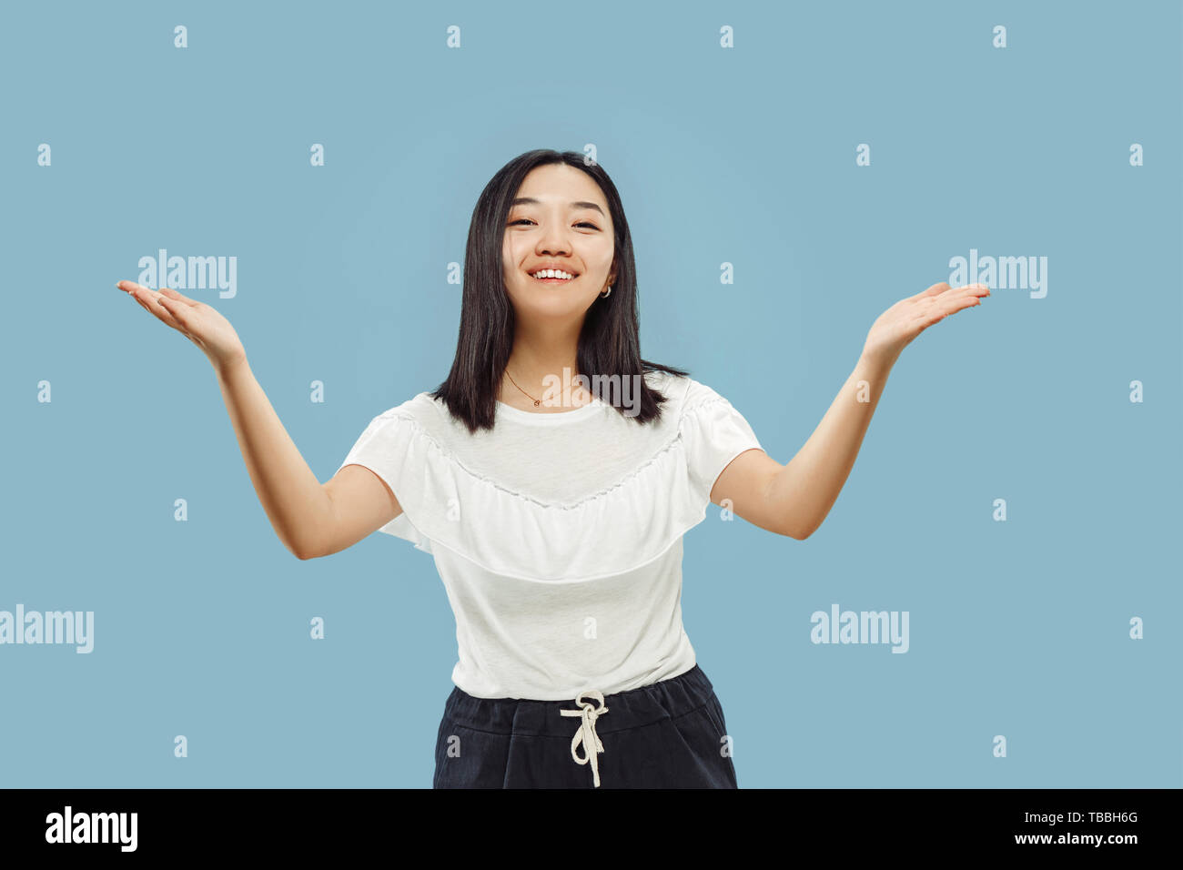 Korean young woman's half-length portrait on blue studio background ...