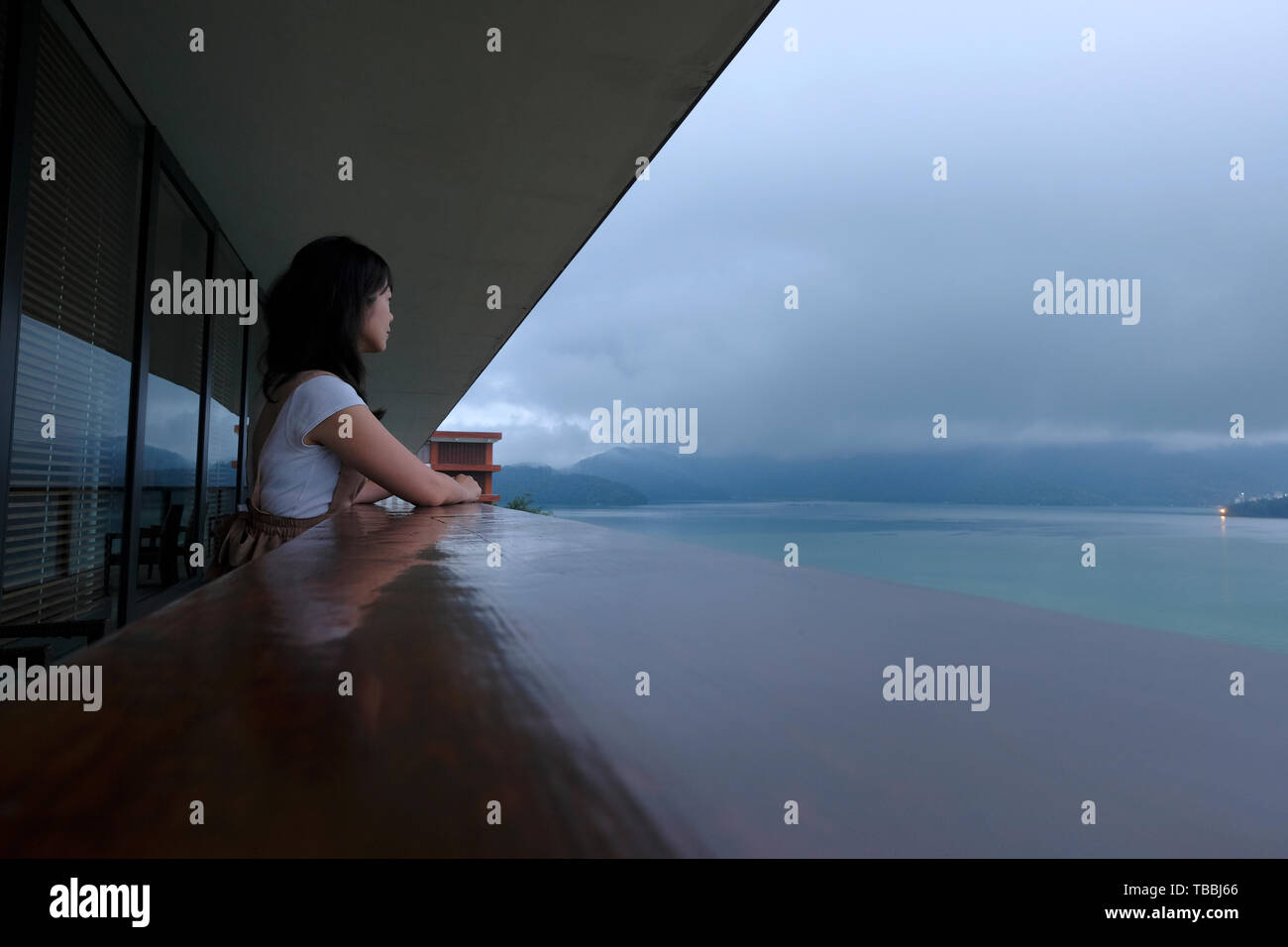 Young woman gazing from Lalu hotel at Sun Moon lake in Yuchi Township ...