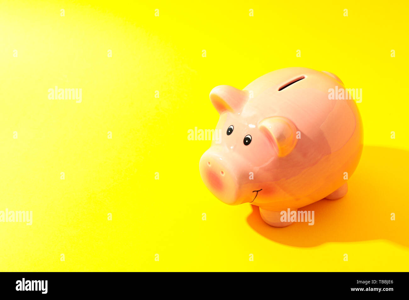 Happy piggy bank on yellow background, space for text. Finance, saving ...