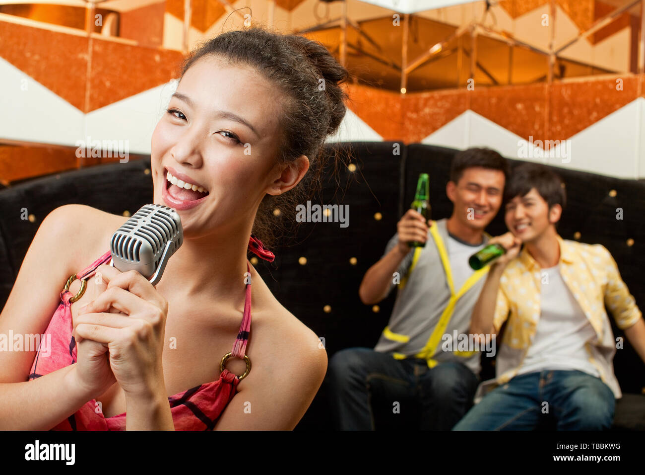 Three friends sing at KTV party Stock Photo - Alamy