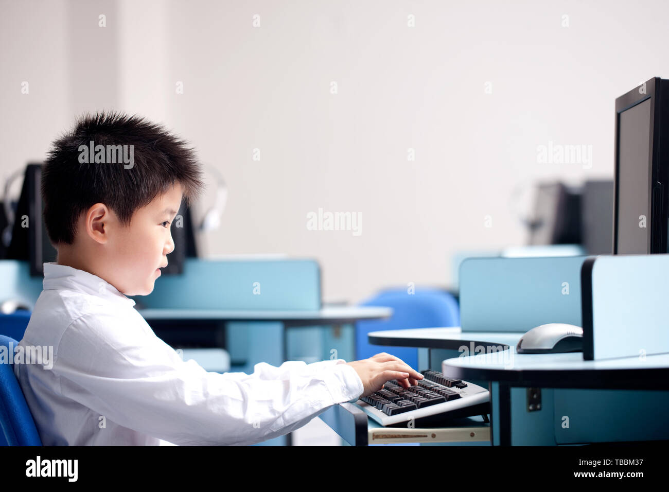 Three primary school students are in class in the classroom Stock Photo ...