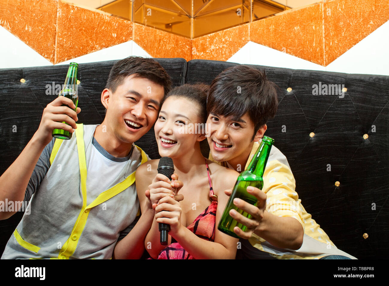 Three friends sing at KTV party Stock Photo - Alamy