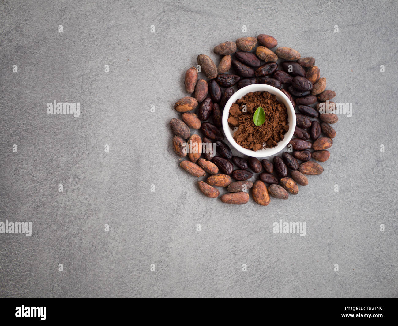 Cocoa powder in a small bowl on a gray stone background, roasted cocoa ...