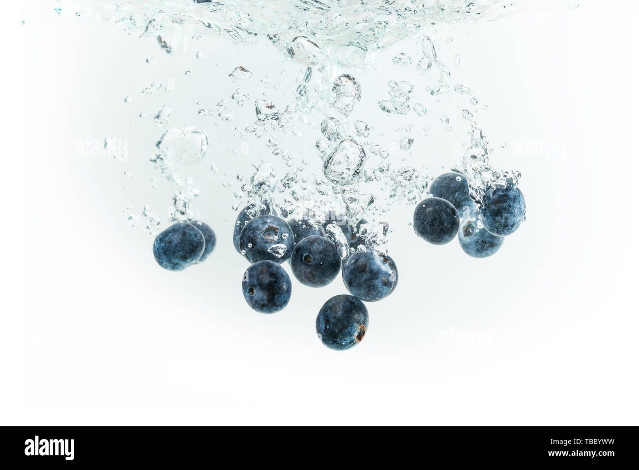 Blueberries sinking underwater with air bubbles isolated on white ...