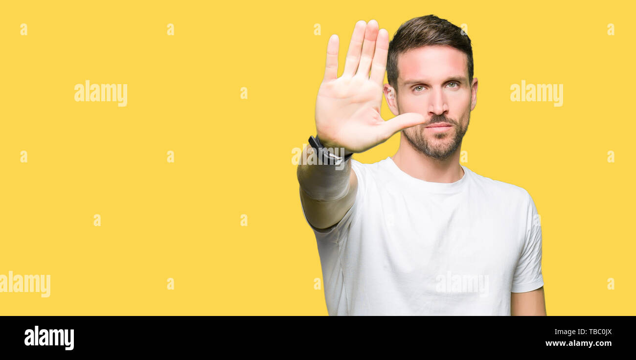 Handsome man wearing casual white t-shirt doing stop sing with palm of ...