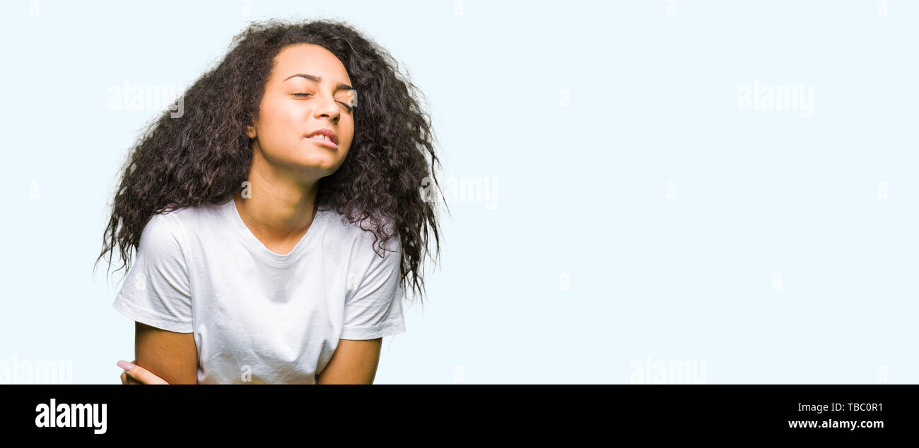 Young beautiful girl with curly hair wearing casual white t-shirt with ...