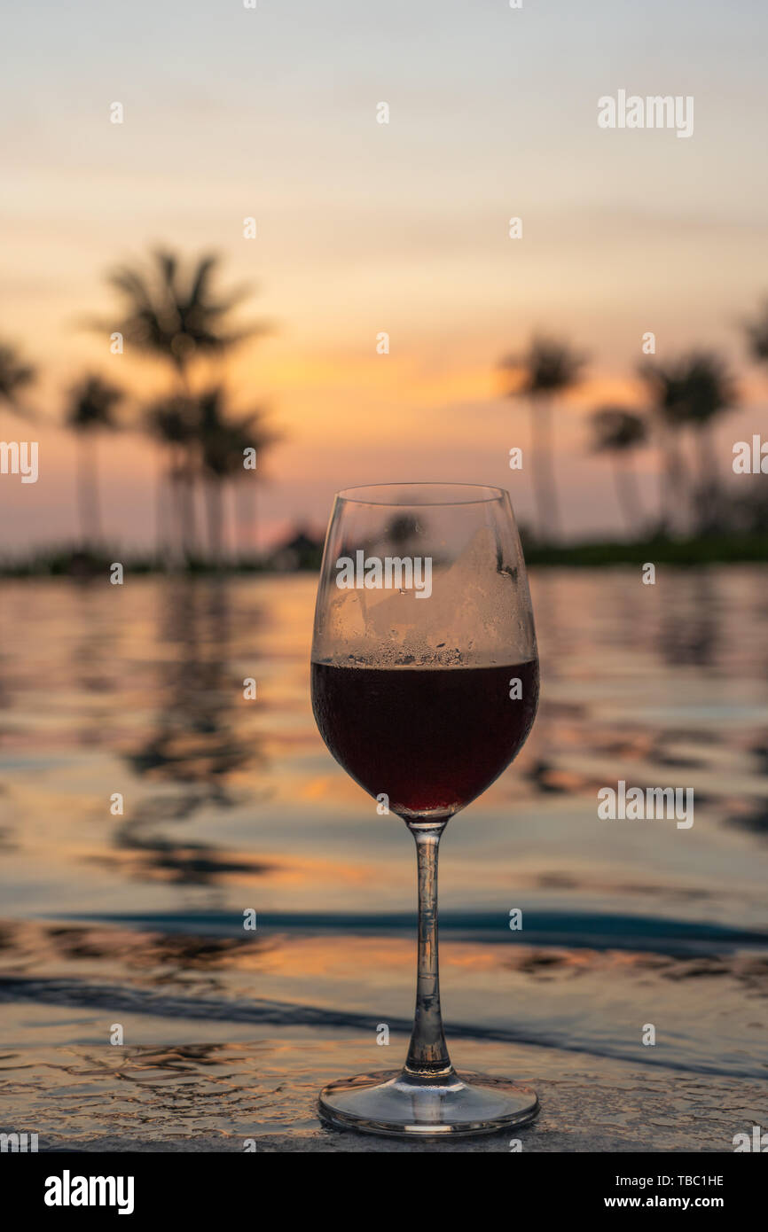 Glass of red wine with swimming pool background Stock Photo - Alamy