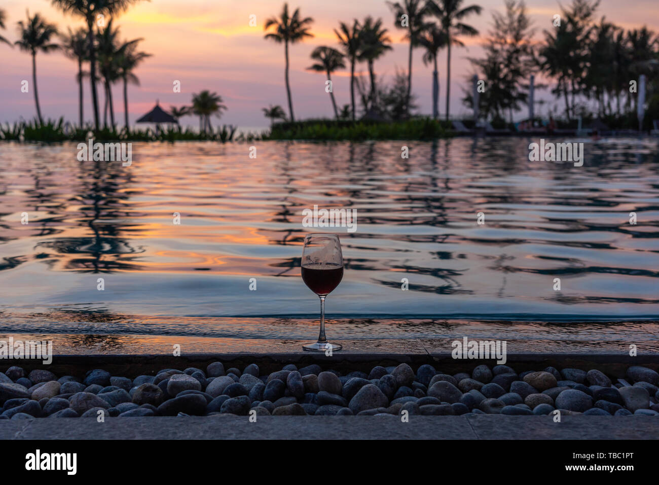 Glass of wine with luxury swimming pool background at sunset Stock ...
