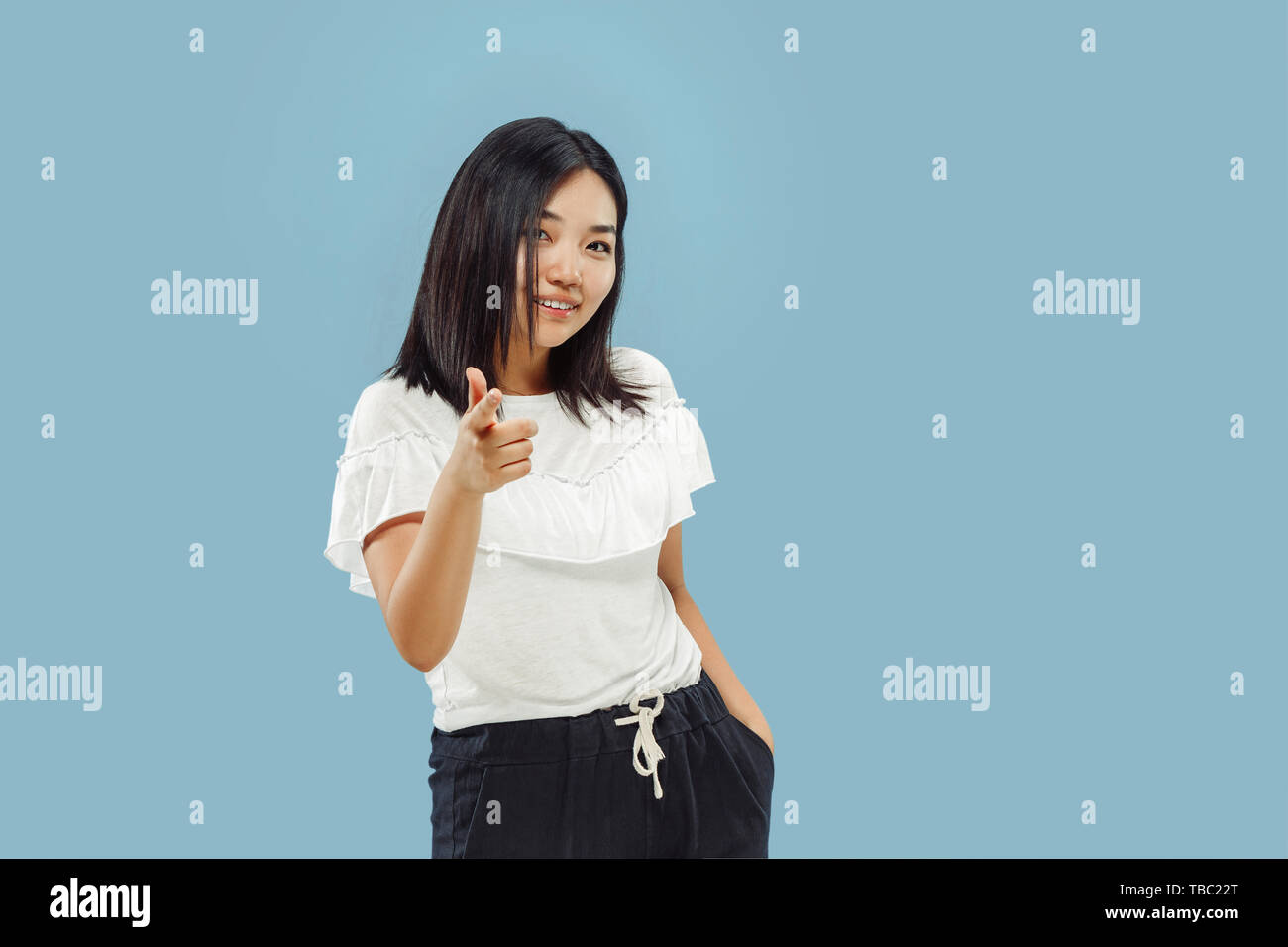 Korean young woman's half-length portrait on blue studio background ...