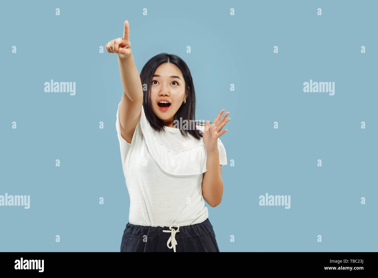 Korean young woman's half-length portrait on blue studio background ...