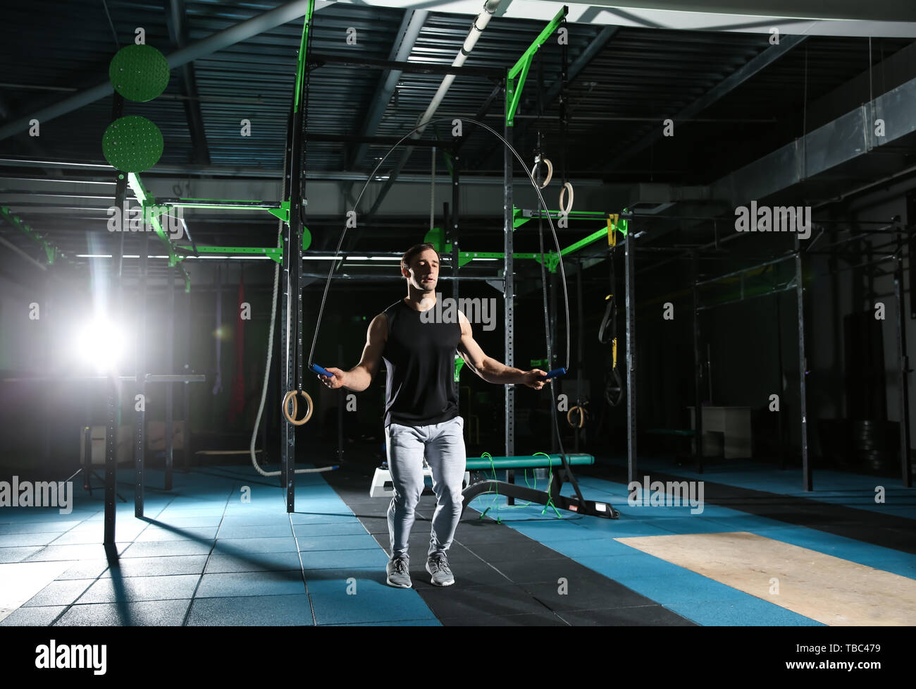 Young sporty man jumping a rope in gym Stock Photo - Alamy