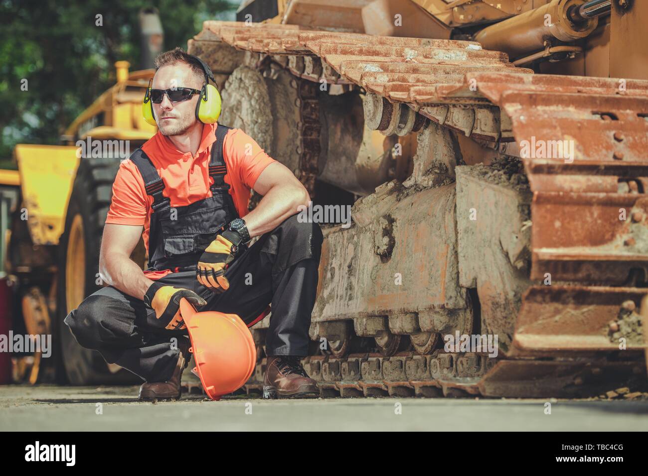 Heavy Duty Equipment Mechanic Side by Side with Aged Bulldozer ...