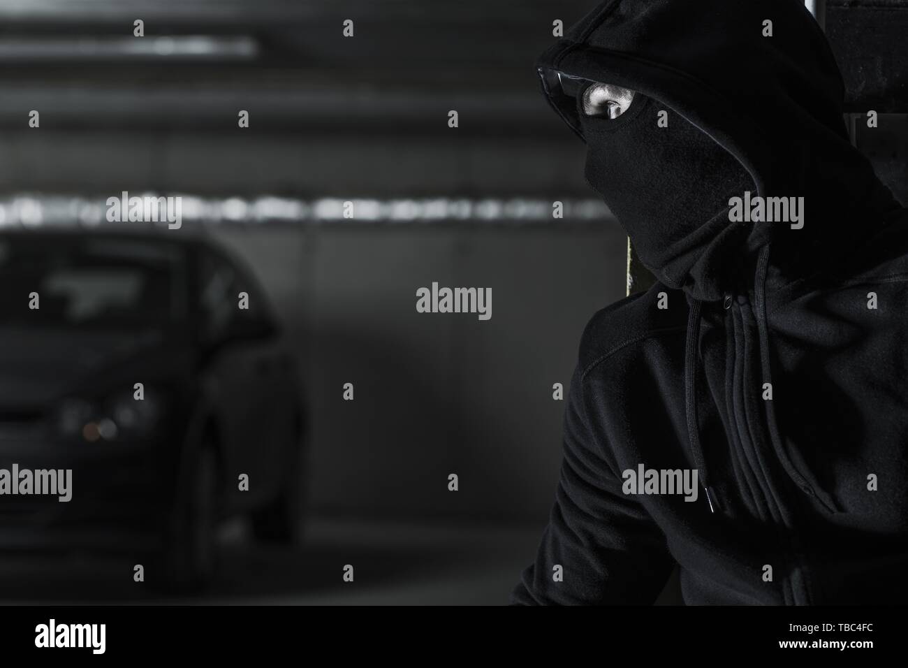 Men in Black Mask is About to Steal Modern Car on a Parking Lot ...