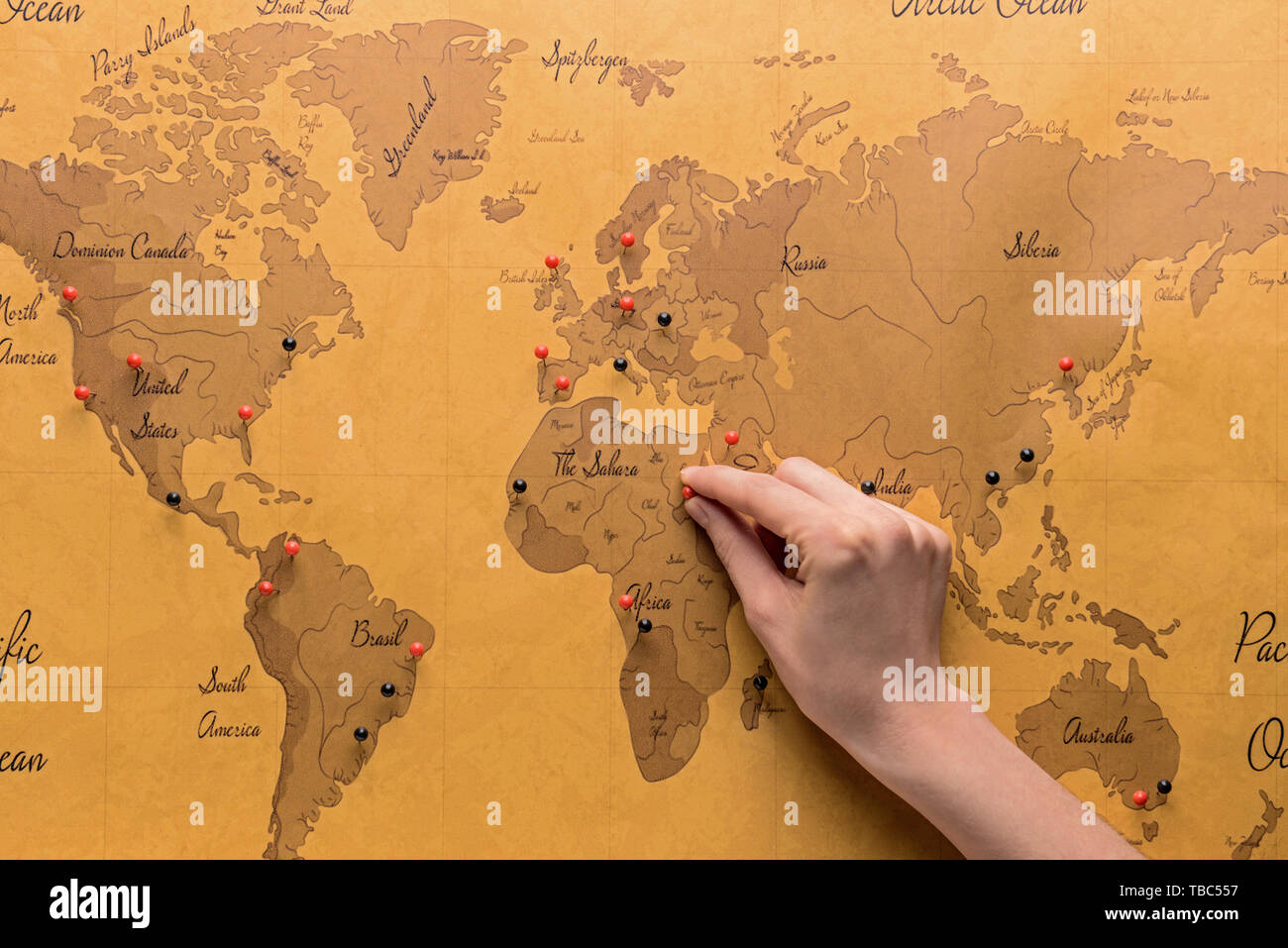 Woman pinning on world map Stock Photo - Alamy