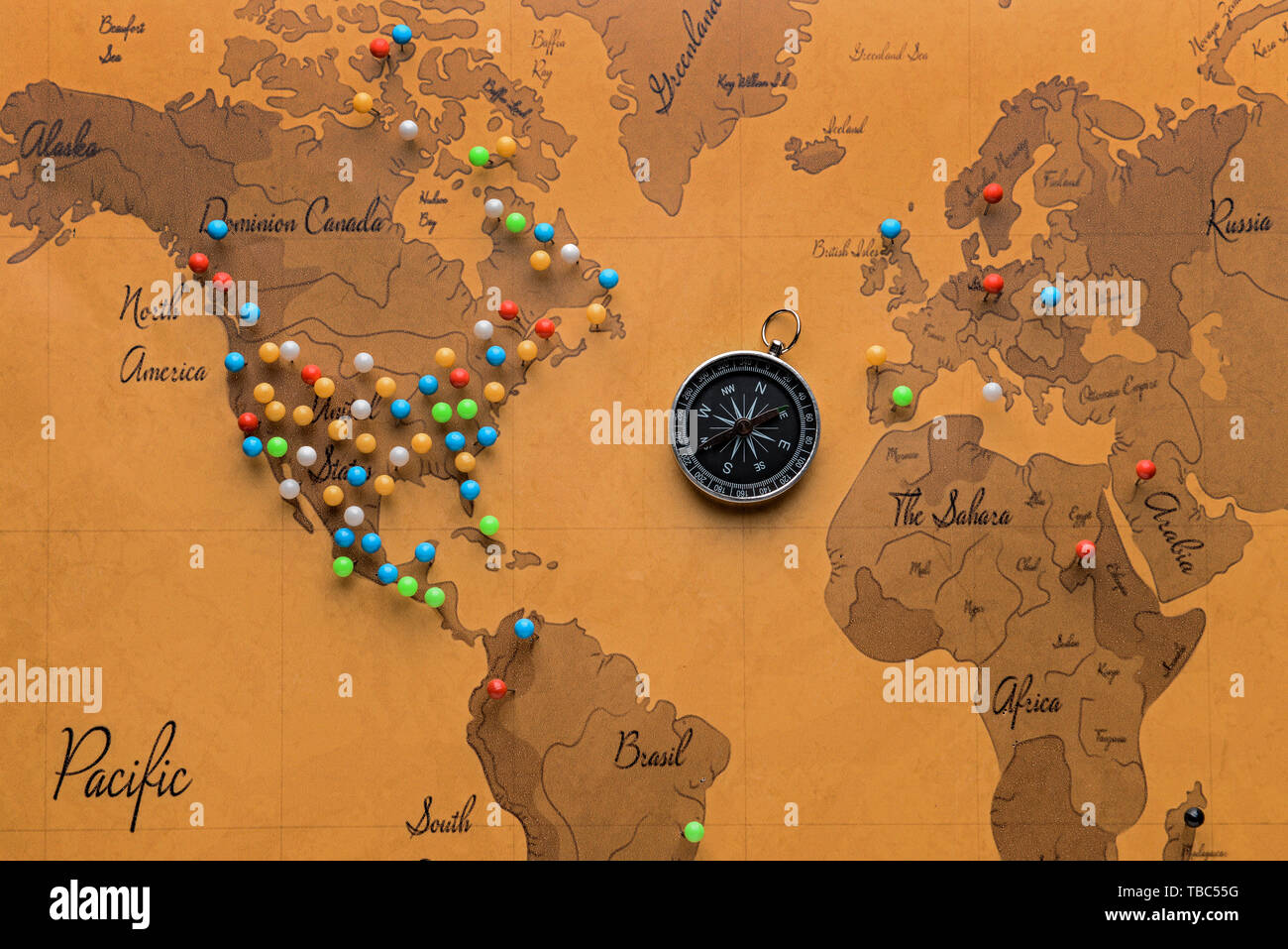 Compass with pins on world map Stock Photo - Alamy