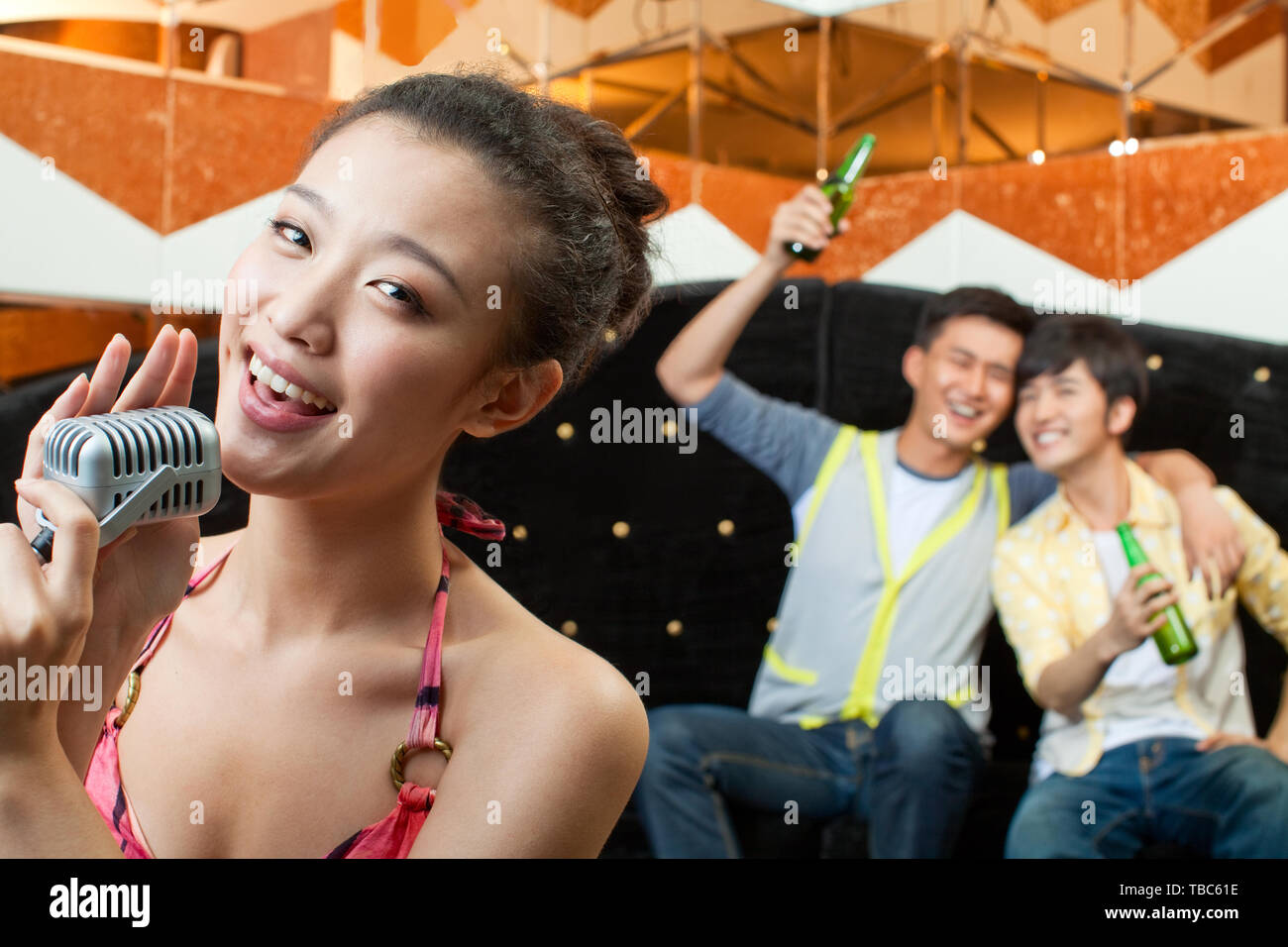 Three friends sing at KTV party Stock Photo - Alamy