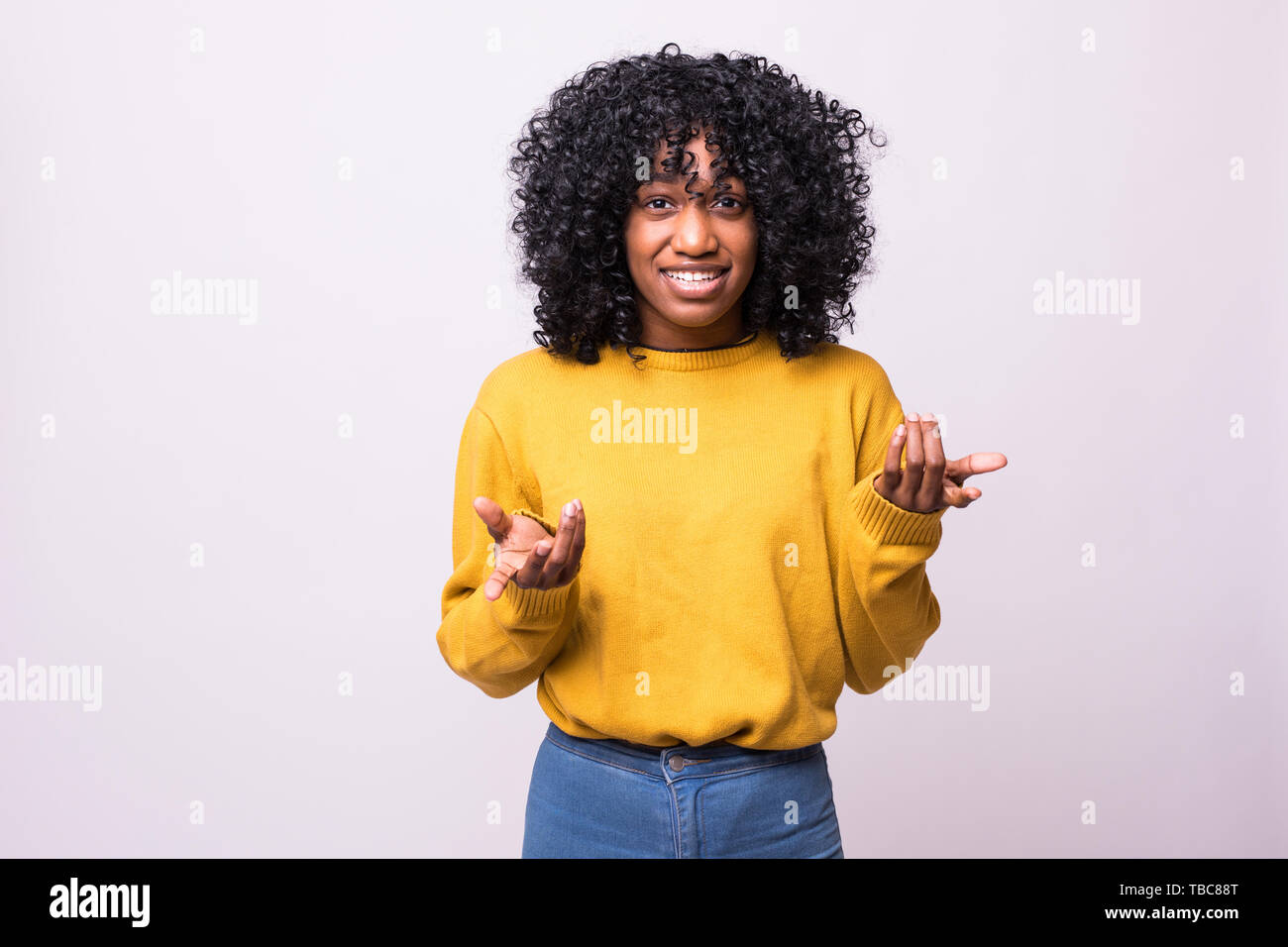 Uncertain African female with dark skin, shruggs shoulders and asks ...