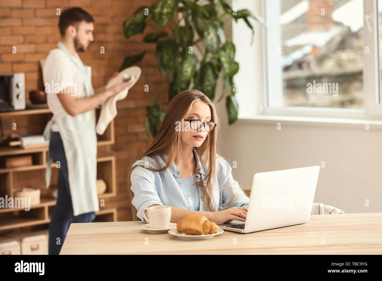 Busy wife working while her husband doing chores at home Stock Photo ...