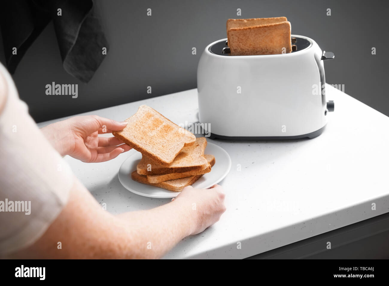 Woman putting tasty toasted bread on plate Stock Photo - Alamy