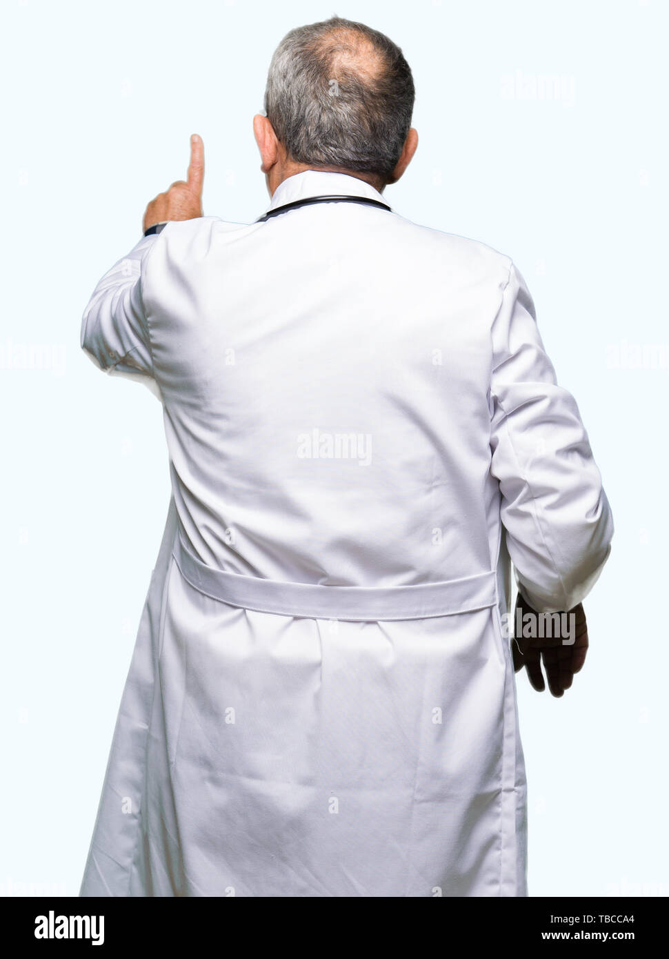 Handsome senior doctor man wearing medical coat Posing backwards ...