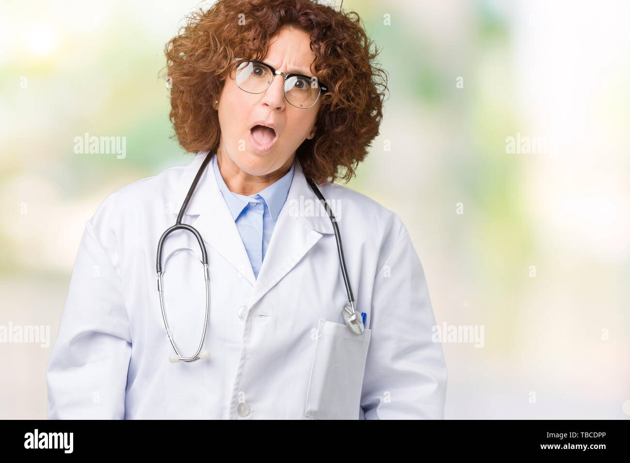 Middle ager senior doctor woman over isolated background In shock face ...